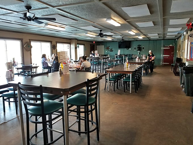 Simple tables, mint-green walls, and ceiling fans spinning lazily overhead – the stage is set for seafood that outshines any fancy décor.