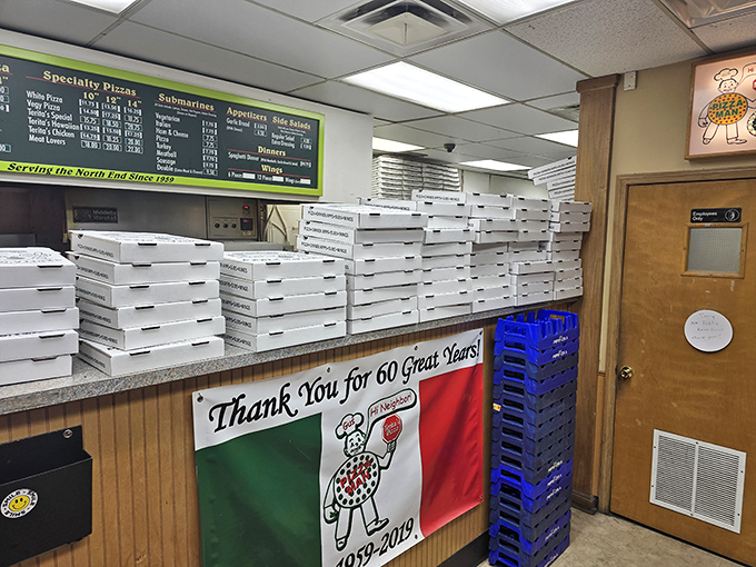 Step inside this wood-paneled time machine where pizza boxes stack like edible skyscrapers of neighborhood pride.