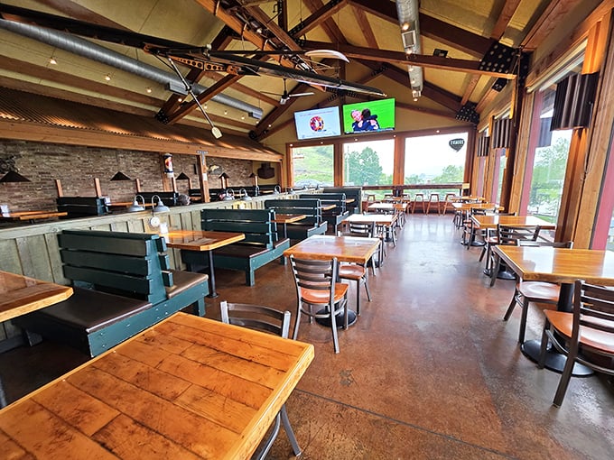 The dining room balances rustic and modern with exposed beams, wooden tables, and large windows that flood the space with natural light.