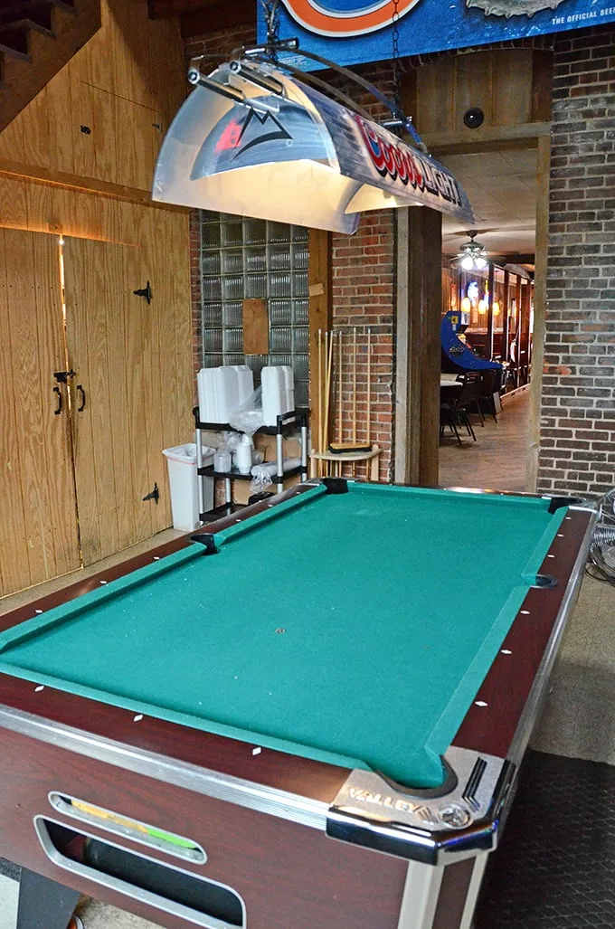 The pool table isn't just decoration—it's the social hub where friendly competitions unfold while burgers sizzle in the background.