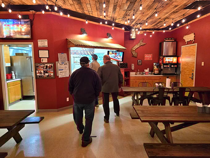 The warm interior feels like a barbecue clubhouse, with rustic wood ceilings, string lights, and picnic tables that say, "Stay awhile, make friends, compare smoke rings."