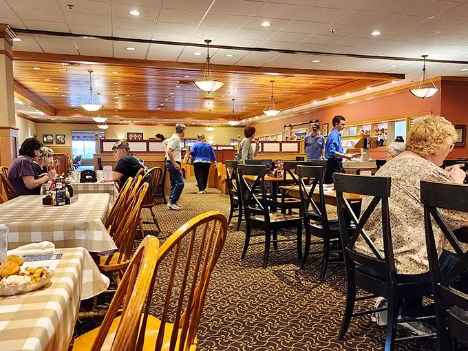 Warm wood tones, checkered tablecloths, and that ceiling that whispers "you're in Amish country now." The restaurant hums with the sound of happy eaters.