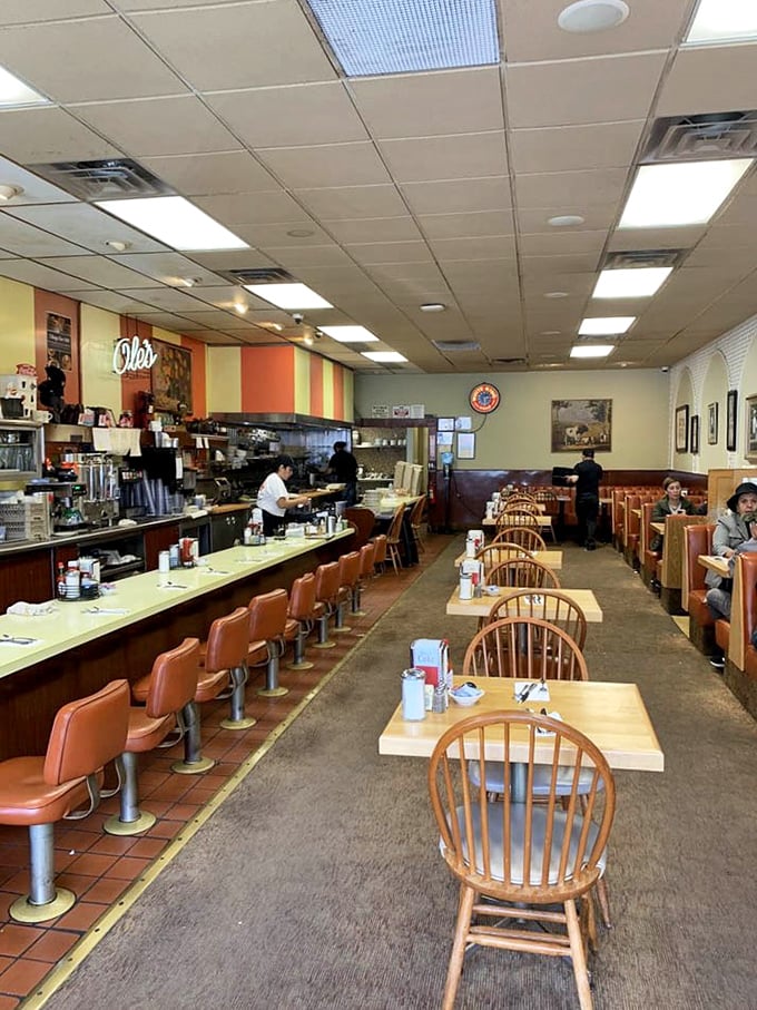Classic diner perfection – orange counter stools, wooden Windsor chairs, and that unmistakable buzz of conversations mingling with the sizzle of the grill.