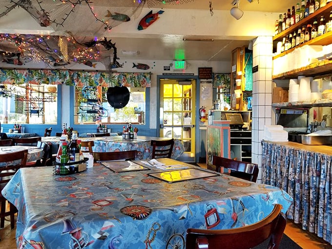 Inside, fishing nets drape from the ceiling while colorful fish decorations create a whimsical underwater world above diners' heads.