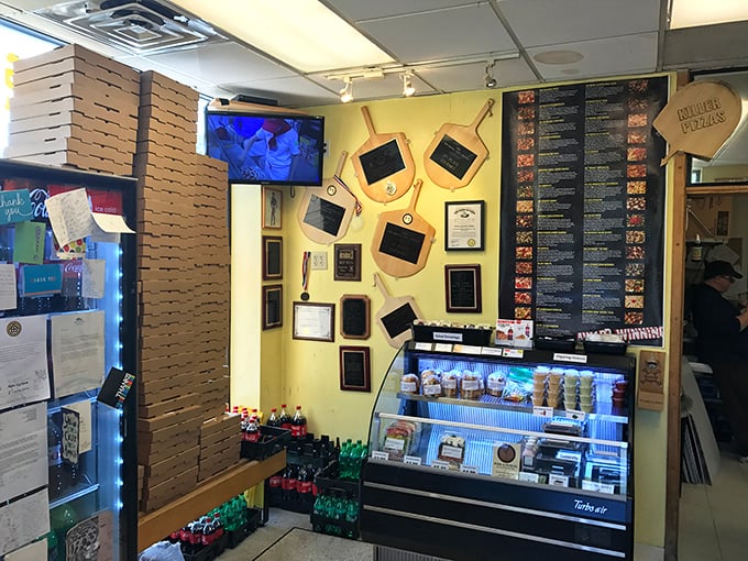 Awards line the walls like trophies in a champion's case, while stacks of pizza boxes stand ready for the dinner rush – organized chaos at its finest.