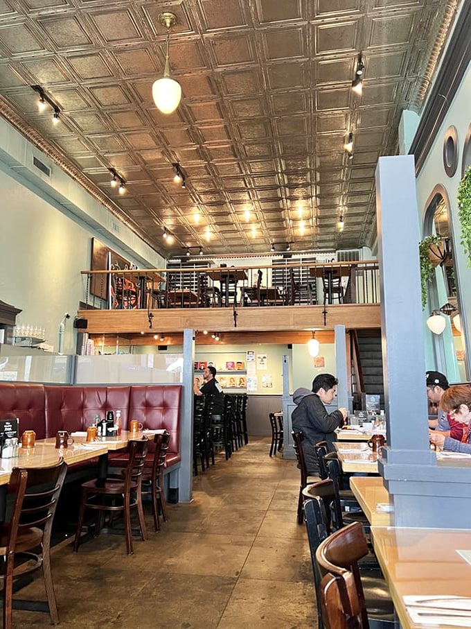 Step inside and be greeted by soaring tin ceilings, warm lighting, and a mezzanine that gives the space a touch of grandeur without sacrificing coziness.