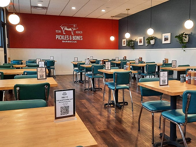 Teal chairs and wooden tables create the perfect canvas for barbecue artistry. The red and blue walls feel patriotic—like the national anthem of smoked meat.