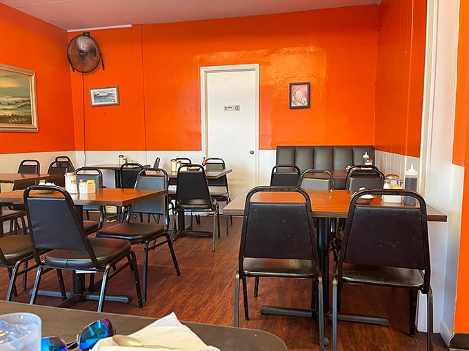 Simple tables and chairs set against cheerful orange walls create that perfect "come as you are" atmosphere where comfort trumps pretension.