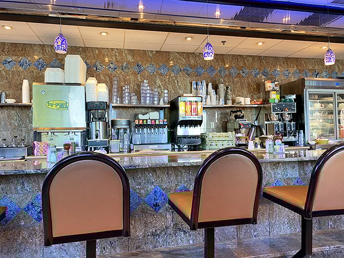 Counter culture at its finest—the marble-topped bar invites solo diners to perch and watch the kitchen symphony unfold beneath purple pendant lights.