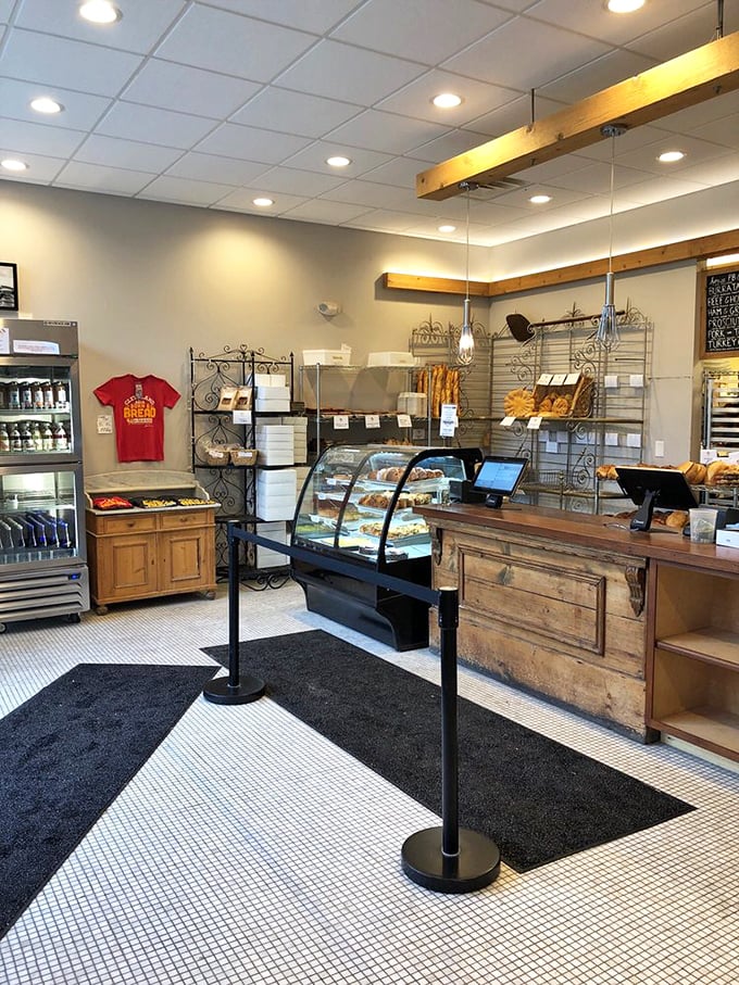 A rustic wooden counter anchors the space, where the real treasures await behind glass. Bread paradise found.