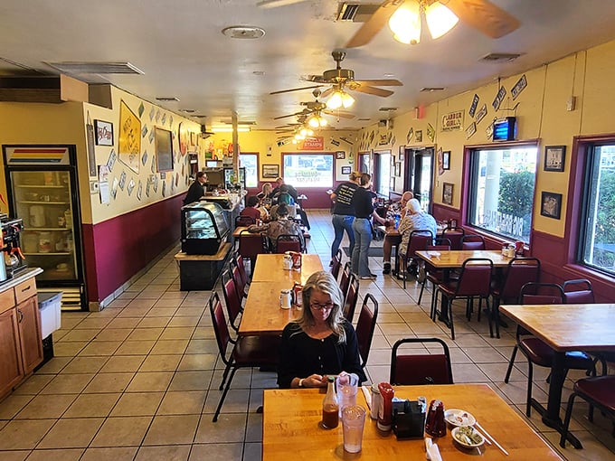Walls dressed in vintage signs, ceiling fans humming—this cozy diner interior feels like a hug in tile and wood.