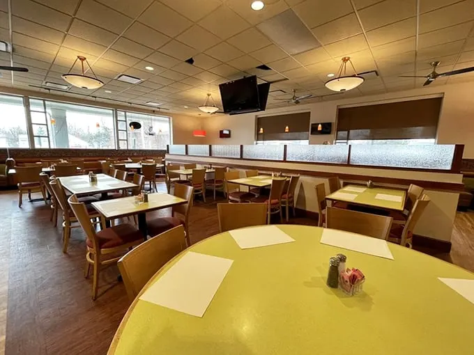 Classic deli ambiance with yellow tabletops and wooden chairs—where comfort trumps trendiness and conversations flow as freely as the coffee refills.