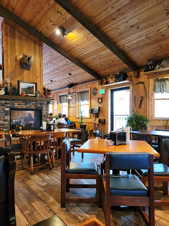 Knotty pine walls, stone fireplace, and wooden beams create the perfect mountain lodge atmosphere. It's like dining in a cozy Appalachian postcard.