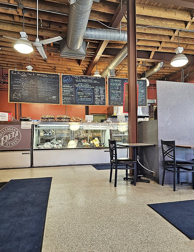 Industrial chic meets comfort food haven – exposed beams and ductwork watch over a space where sandwich artistry happens daily.