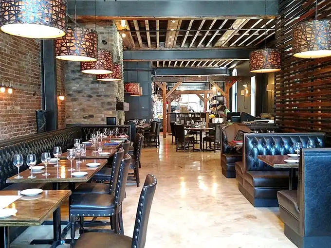 Industrial chic meets cozy comfort in this dining room where exposed brick and leather booths create the perfect backdrop for carnivorous adventures.