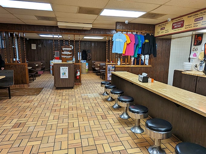 Step inside and time travel to a simpler era. Wood paneling, classic counter stools, and colorful t-shirts create the perfect backdrop for donut-fueled conversations.