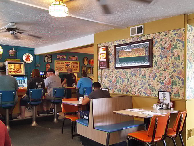 Step inside and time stands still—floral wallpaper, turquoise walls, and orange vinyl booths create the perfect symphony of classic Americana diner charm.