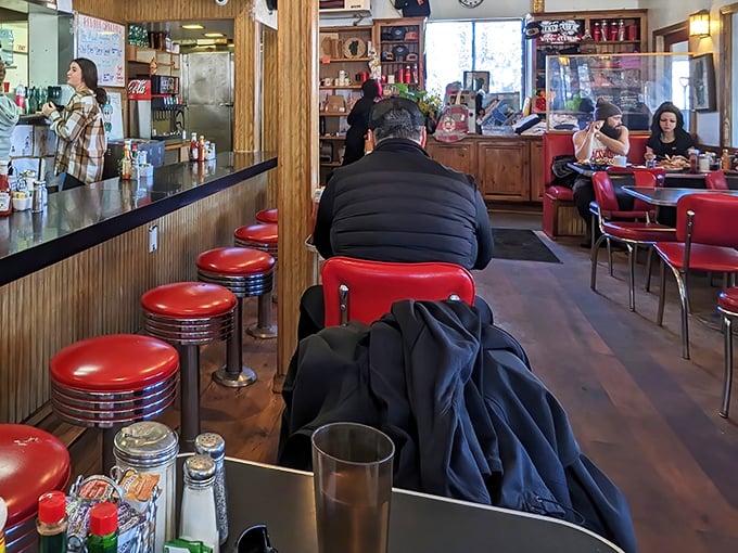 Classic red vinyl stools and wood paneling create that perfect time-capsule diner vibe. No Instagram filters needed—this authenticity comes naturally.