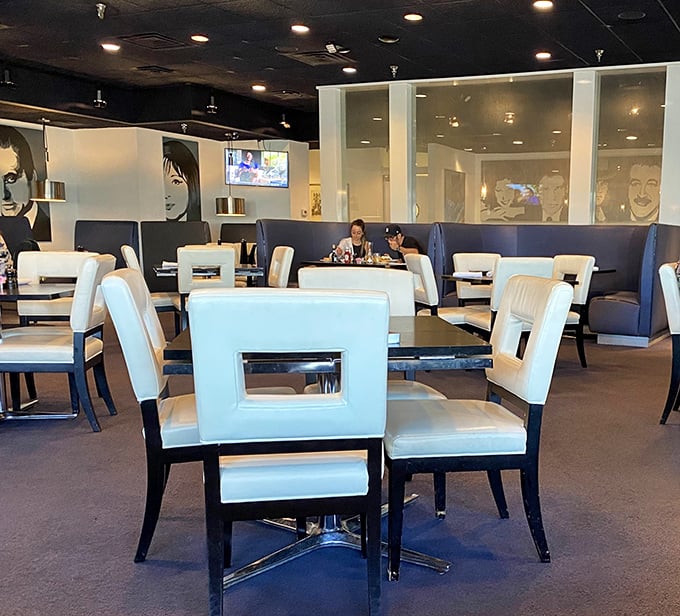 Step inside and you're greeted by a modern twist on classic deli ambiance—white geometric chairs and blue booths create a space that's both stylish and comfortable.