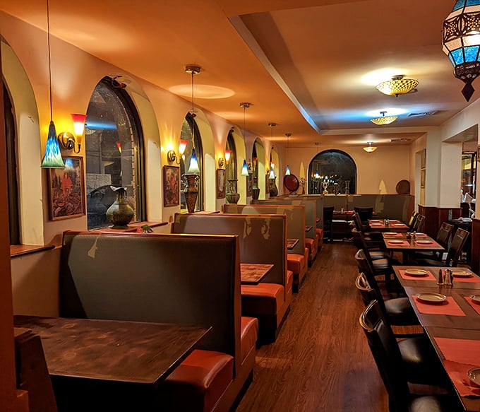 Step inside and the warm glow of colorful lamps transforms the space into an intimate dining experience. The arched windows and cozy booths invite you to settle in.