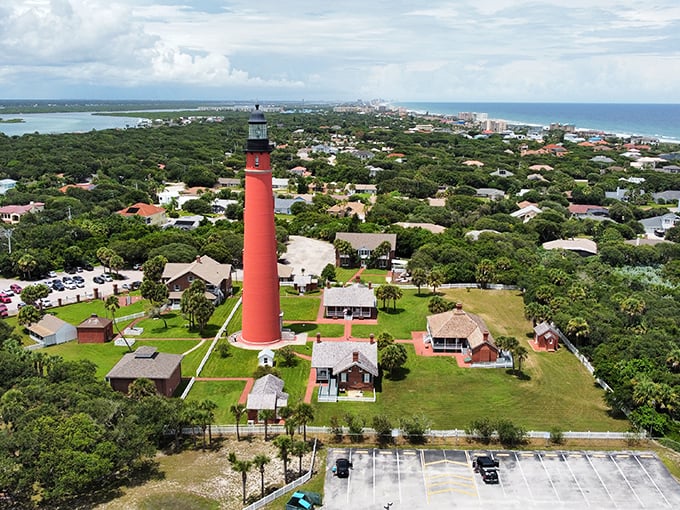 This isn't just any red lighthouse – it's Florida's oldest, standing sentinel over St. Augustine since 1874, surrounded by lush coastal greenery.