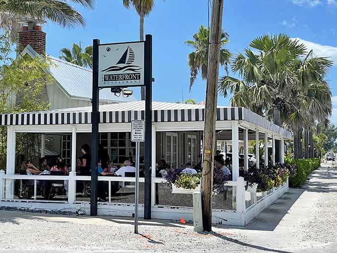 The Waterfront Restaurant's black and white awning isn't just stylish – it's a beacon for seafood lovers seeking shade and sustenance.