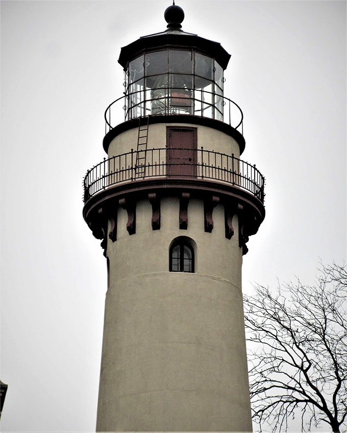 Looking up at the lighthouse's crown jewel—its distinctive lantern room where the historic Fresnel lens once guided countless ships to safety.