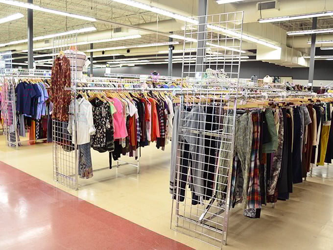 Clothing racks stretch as far as the eye can see—a textile jungle where vintage gems hide among everyday basics, waiting for their second chance.