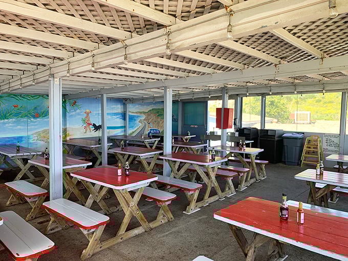 Red-trimmed picnic tables under a latticed ceiling – where memories are made between bites of perfectly fried fish and ocean-view conversations.