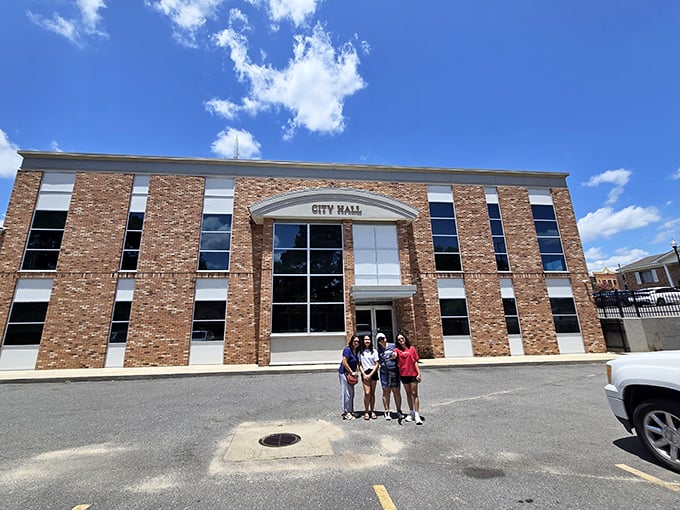 City Hall stands as a brick testament to small-town governance – where permits are processed with a smile and a "how's your mama doing?"