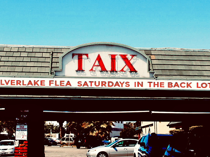The iconic Taix sign stands as a beacon for bargain hunters, announcing the weekend transformation of this parking lot into a shopper's paradise.