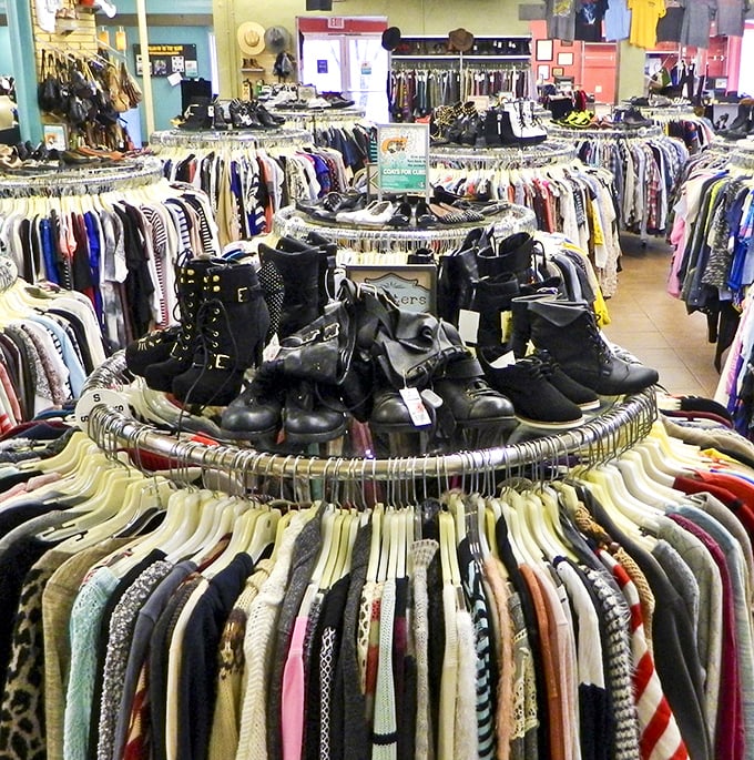 Circular racks create a treasure hunter's paradise where vintage leather boots hold court at the center of a fashion universe.