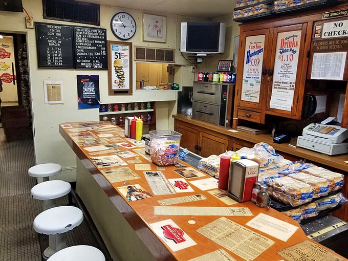 Six stools, one counter, and a century of burger history preserved under glass—this isn't dining, it's time travel with onions.