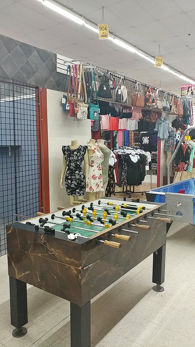Where fashion meets foosball! This vendor's creative display showcases both stylish dresses and entertainment options—proof that shopping here is never just shopping.