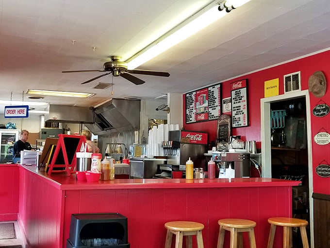 The heart of burger paradise beats behind this vibrant red counter, where culinary magic happens with delicious simplicity.