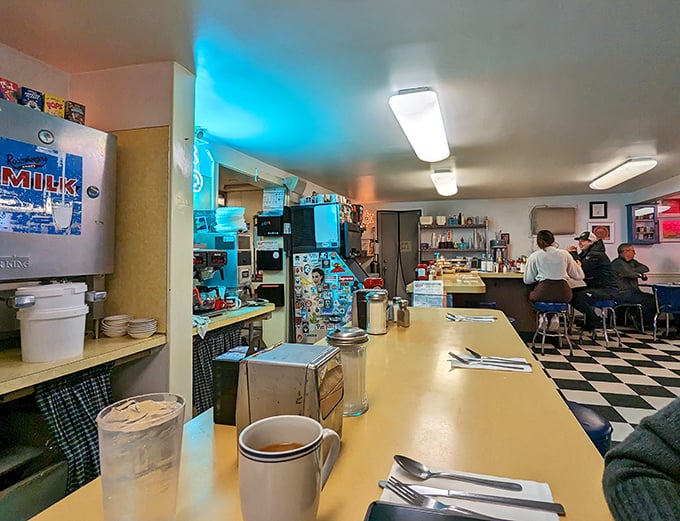 Step inside where checkered floors meet comfort food dreams and coffee flows like liquid gold.