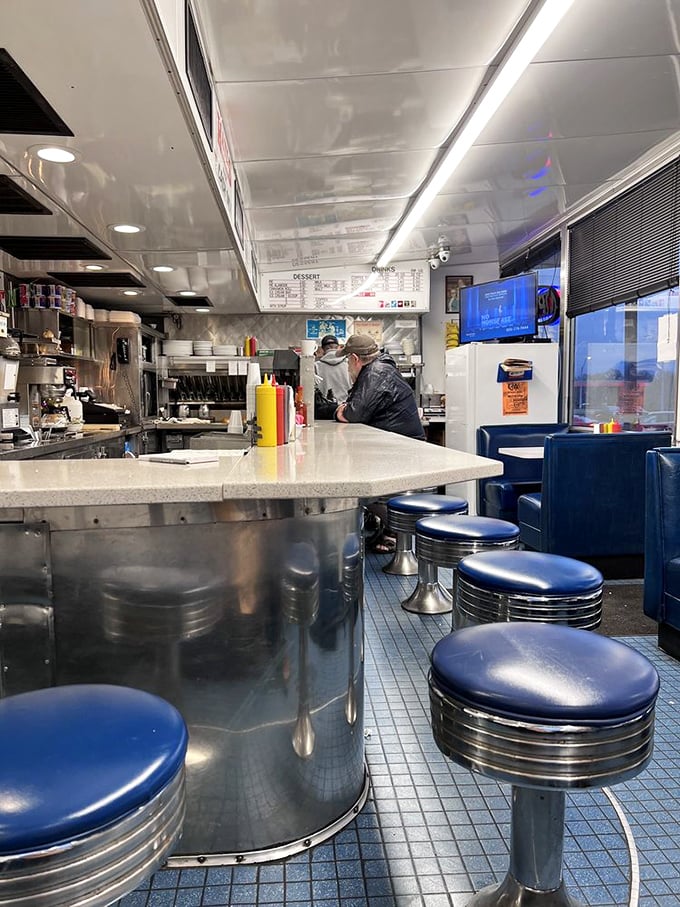 Inside, the gleaming counter and classic blue stools offer front-row seats to the burger ballet that's been perfected over decades on that well-seasoned grill.