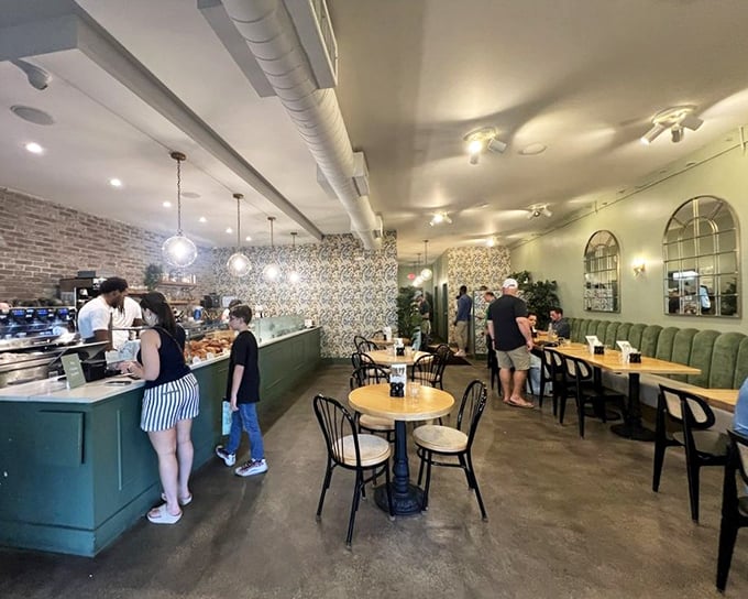Inside, exposed brick meets elegant wallpaper in a space that feels both sophisticated and comfortable—the Goldilocks zone of café ambiance.