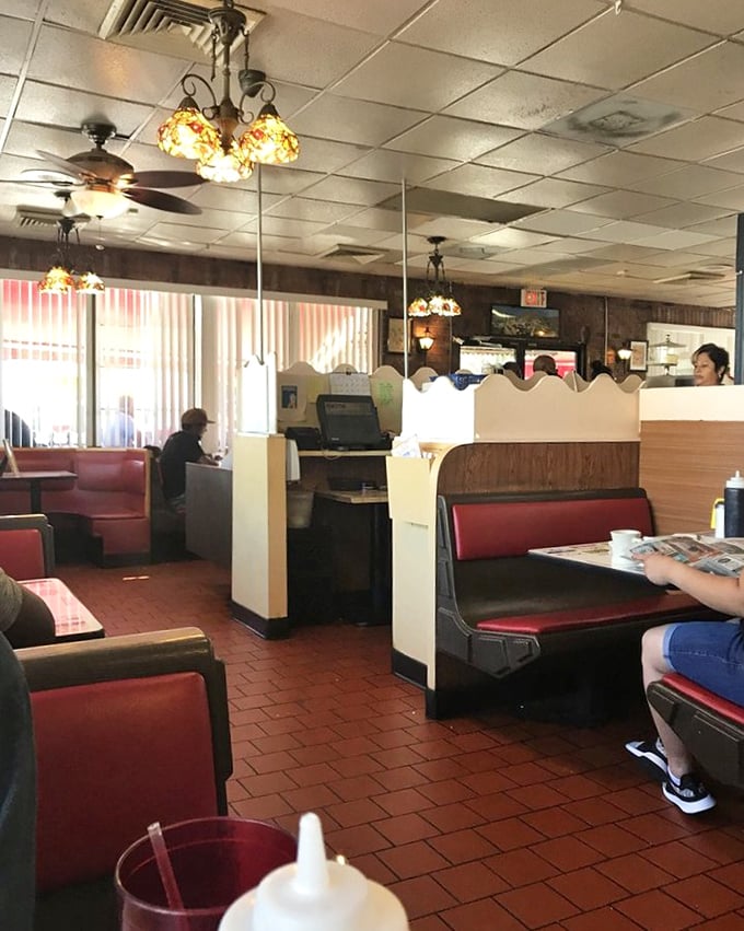 Step into a time machine where red vinyl booths have witnessed decades of first dates, family celebrations, and solo diners savoring that perfect bite.