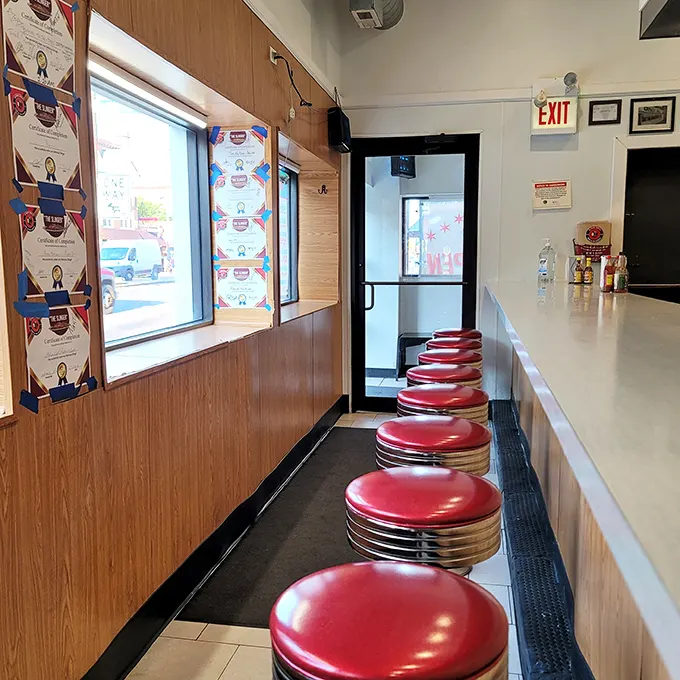 Those cherry-red counter stools aren't just seating – they're front-row tickets to the best breakfast show in Chicago, complete with sizzling sound effects.