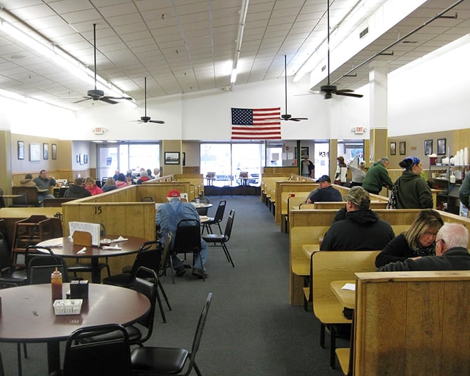 Classic Americana at its finest – wooden booths, an American flag, and the gentle hum of conversation. This isn't décor; it's comfort materialized.