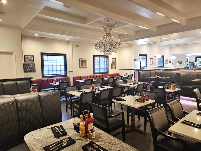 Crystal chandeliers and burgundy banquettes create an atmosphere where every meal feels like a celebration.