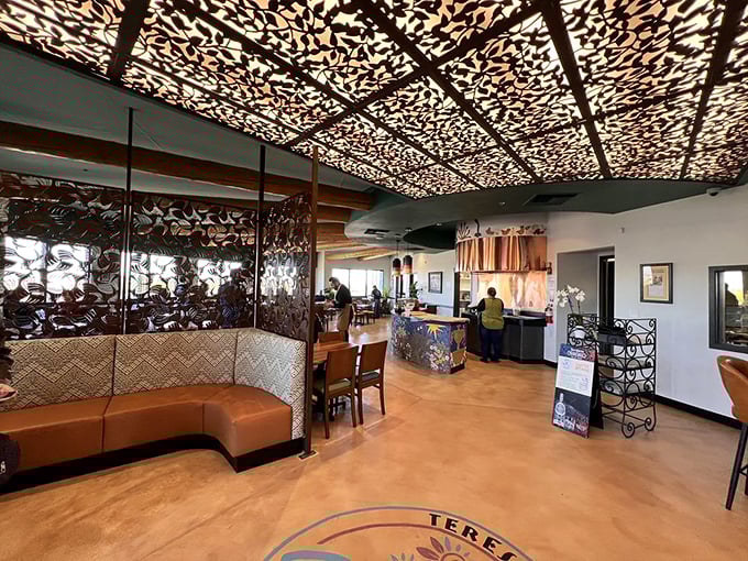Stepping inside feels like entering an art installation where food is the main exhibit. That intricate ceiling transforms ordinary lighting into a dance of shadows.