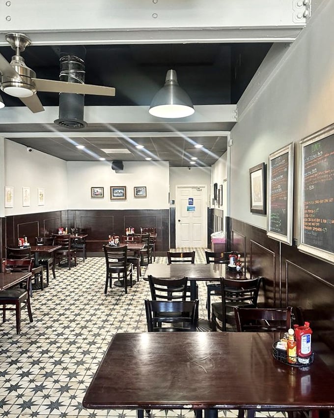 Classic black and white tiles meet warm wood wainscoting in this cozy interior that feels like breakfast at your coolest friend's house—if your friend were an exceptional cook.