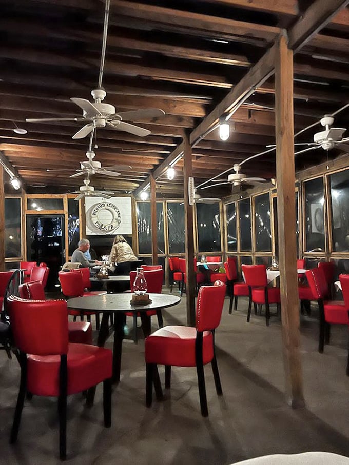 Those vibrant red chairs aren't just a pop of color – they're the perfect perch for seafood enthusiasts who know that sometimes the best dining rooms look like ship cabins.
