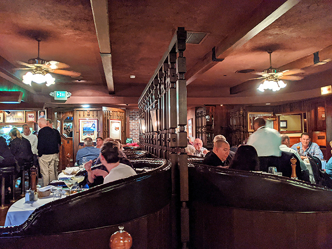 Dark wood booths, curved partitions, and the gentle hum of satisfaction—this is what steakhouse dreams are made of.