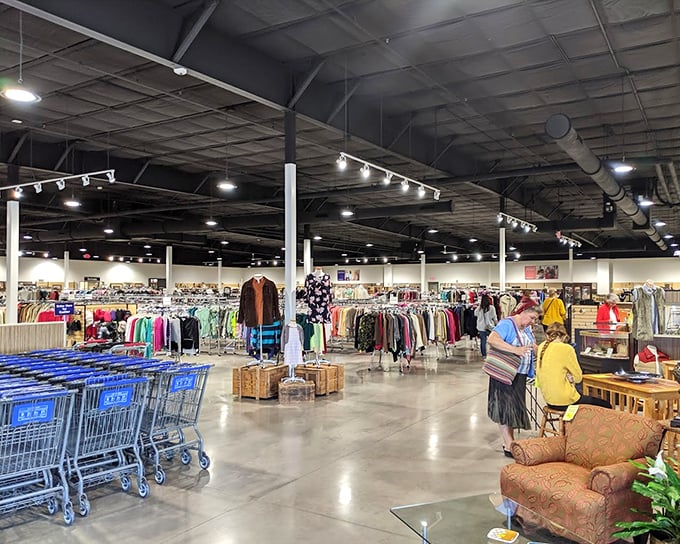 A thrifter's paradise stretches before you—racks of possibility, blue carts awaiting adventure, and furniture that whispers, "Take me home for less than dinner out."
