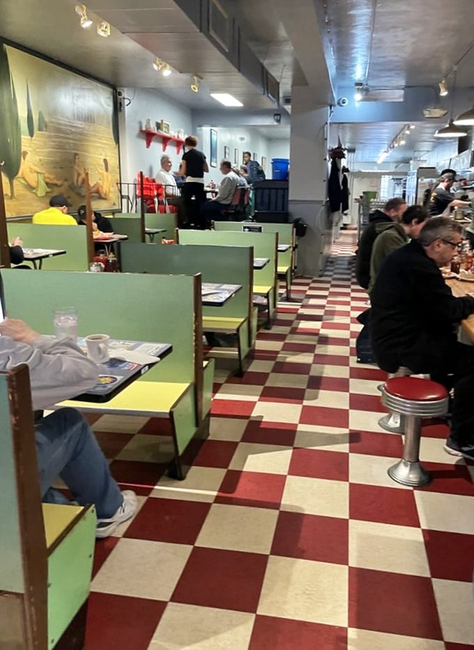 The classic diner interior feels like a time capsule with its checkerboard floor and mint-green booths—comfort before your comfort food arrives.