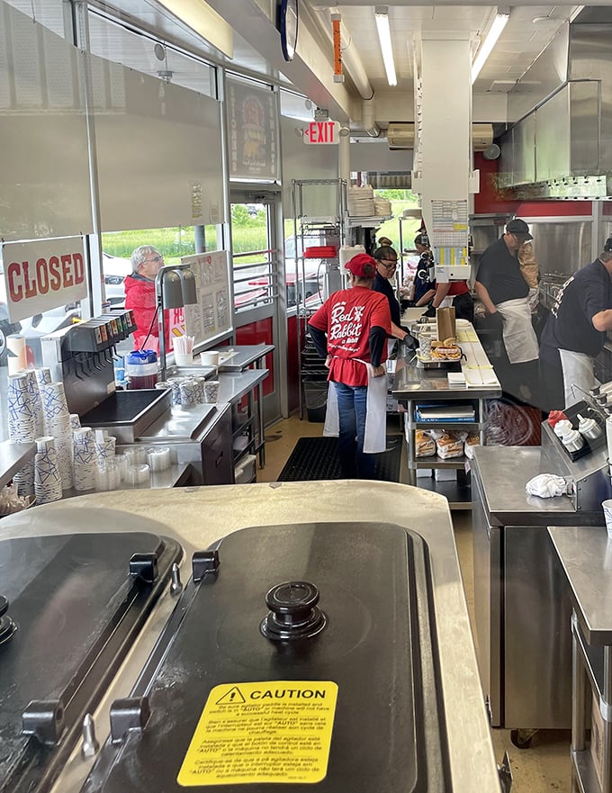 Behind the scenes magic happens in this bustling kitchen, where staff in signature red aprons craft the comfort food classics that keep generations coming back.