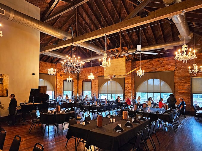 Crystal chandeliers dance above exposed brick walls and wooden beams, creating that rare alchemy where industrial chic meets Southern hospitality.